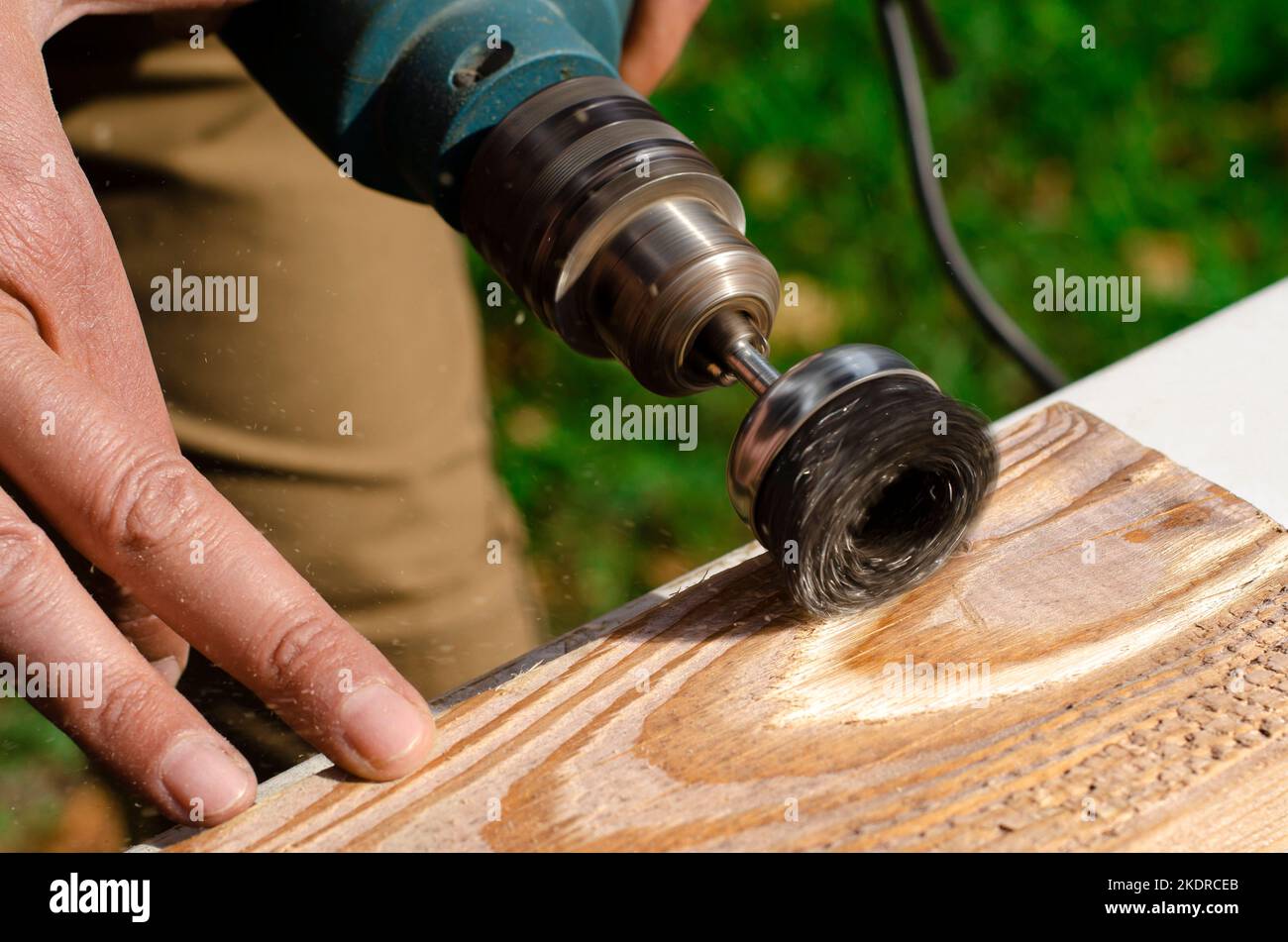 Male hand is holding brushing machine electrical rotating with metal ...