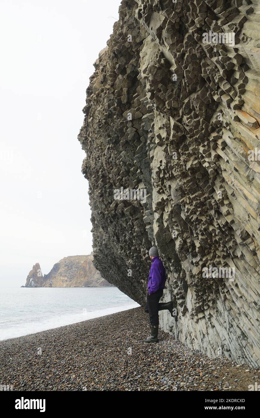 Seascape. The boy is under the rock by the sea Stock Photo - Alamy