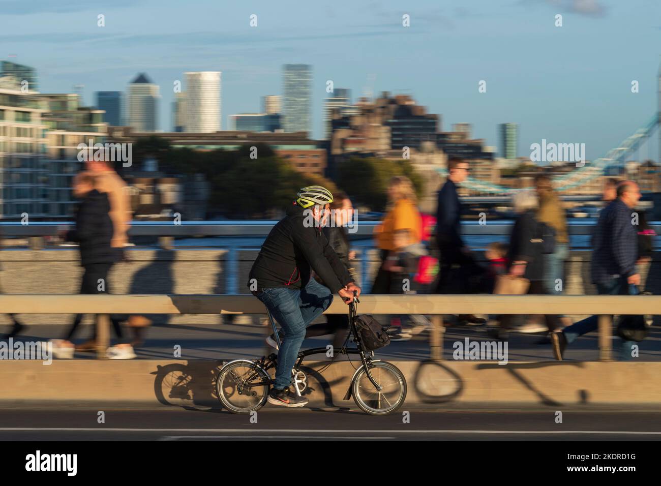 A male commuter riding a Brompton folding bicycle across London Bridge ...