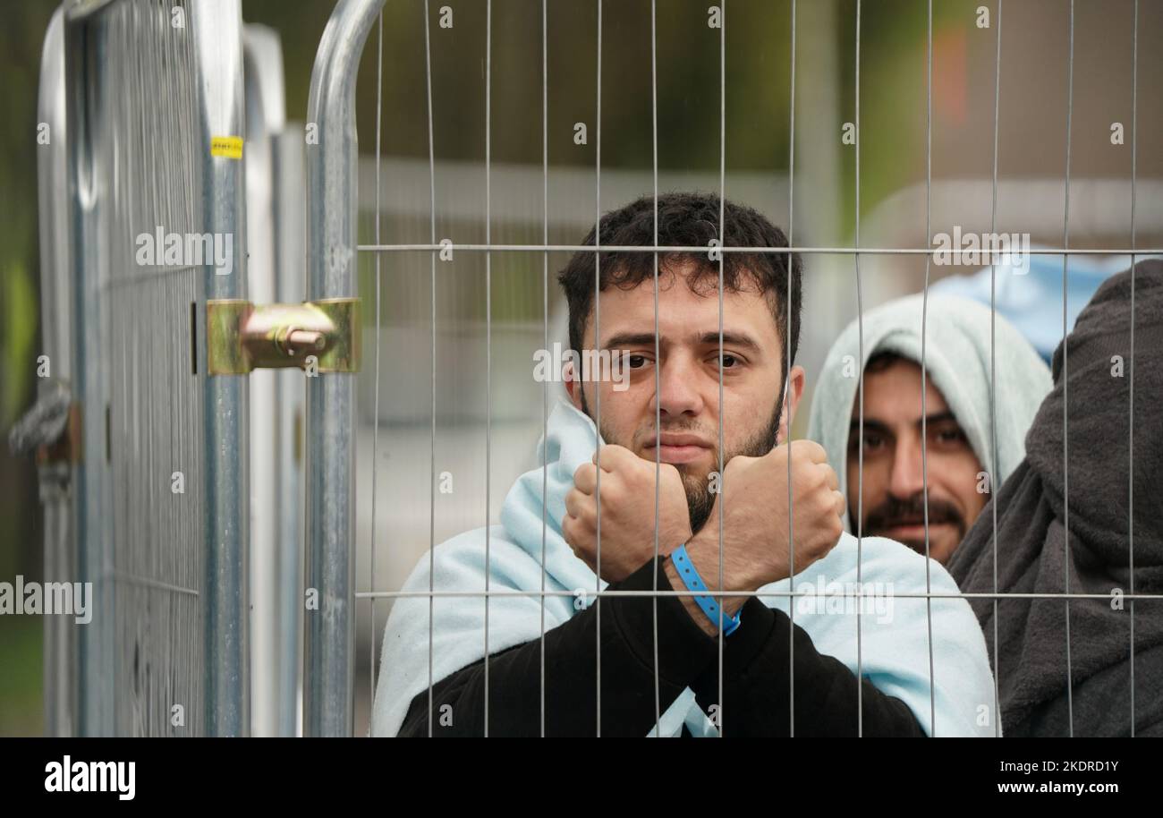 Men thought to be a migrants gesture towards members of the media at ...