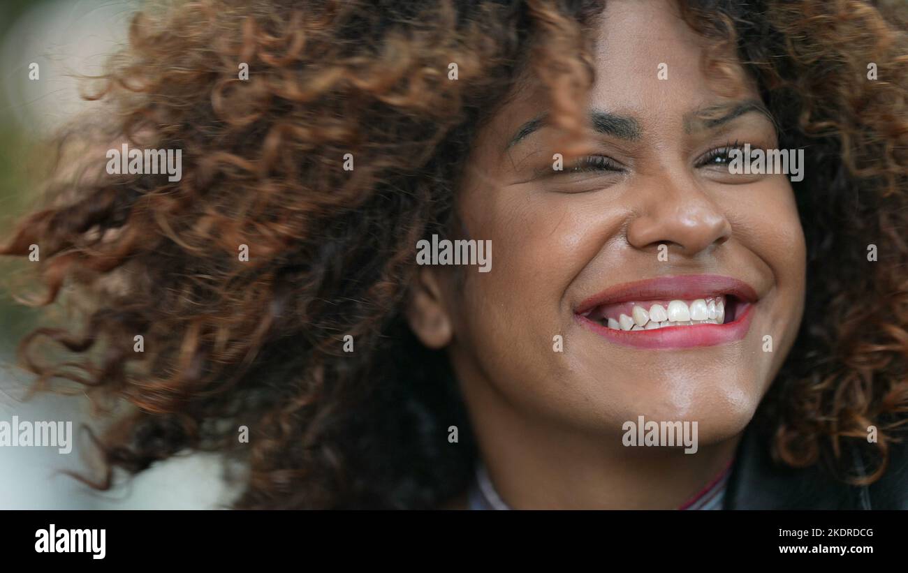 Carefree latina black woman shaking hair and smiling at camera Stock ...