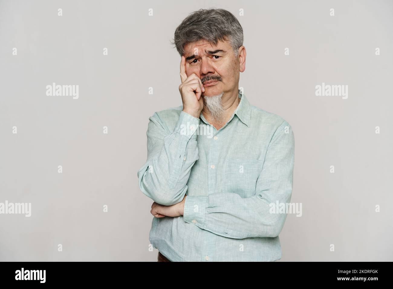 Senior sad man with mustache and beard looking at camera isolated over ...