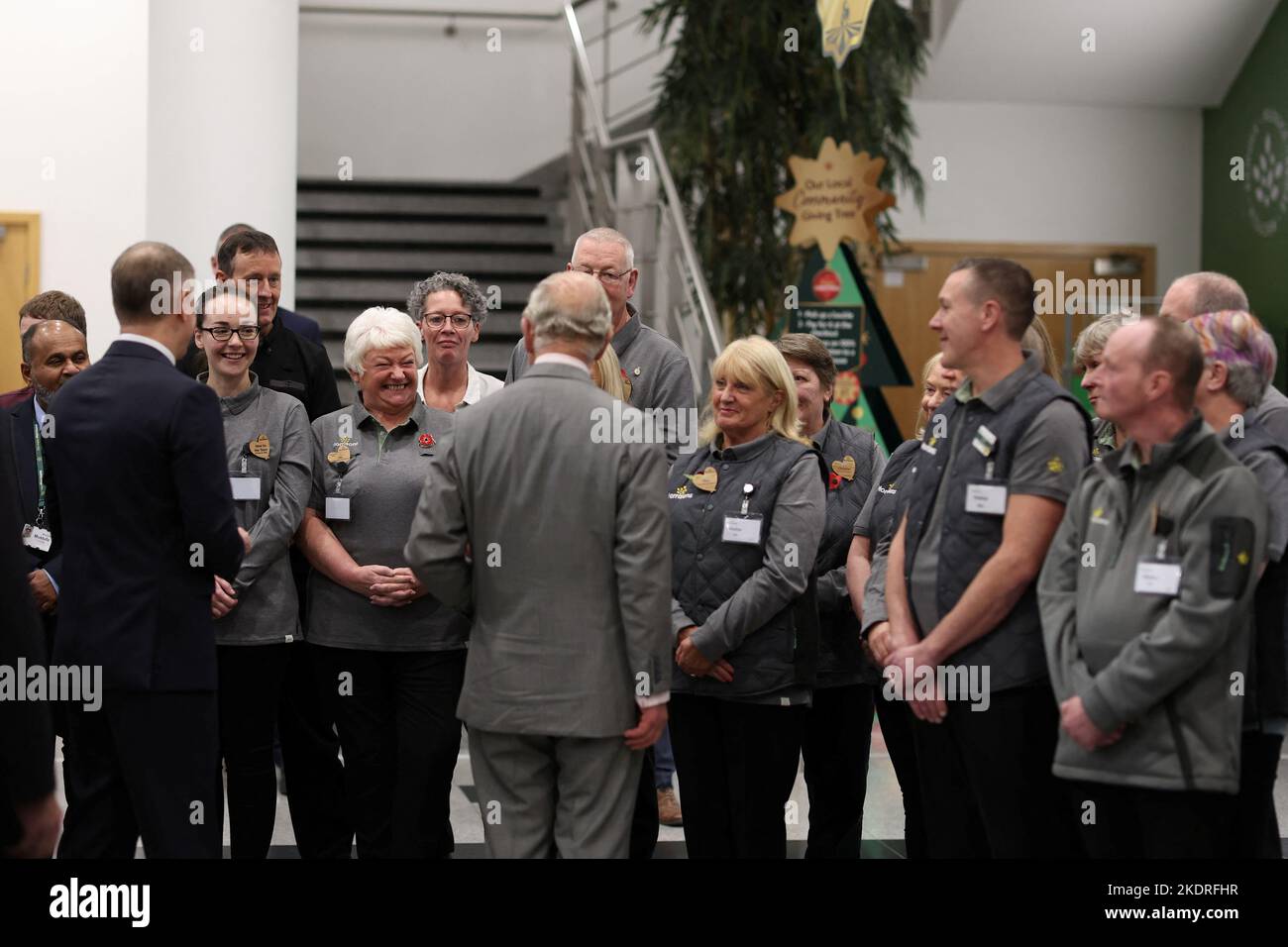 King Charles III speaks to members of staff during a visit to the head ...