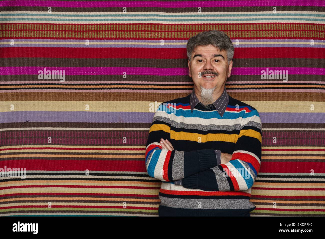 Mature man with grey beard smiling and looking at camera isolated over ...
