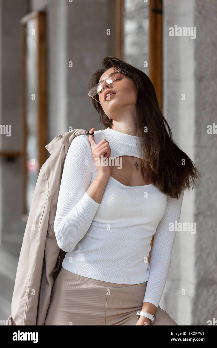 beautiful brunette girl in a sunglasses dressed in white blouse with a ...