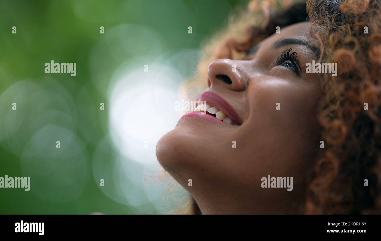 Happy Brazilian woman worshipping God looking up at sky smiling Stock ...