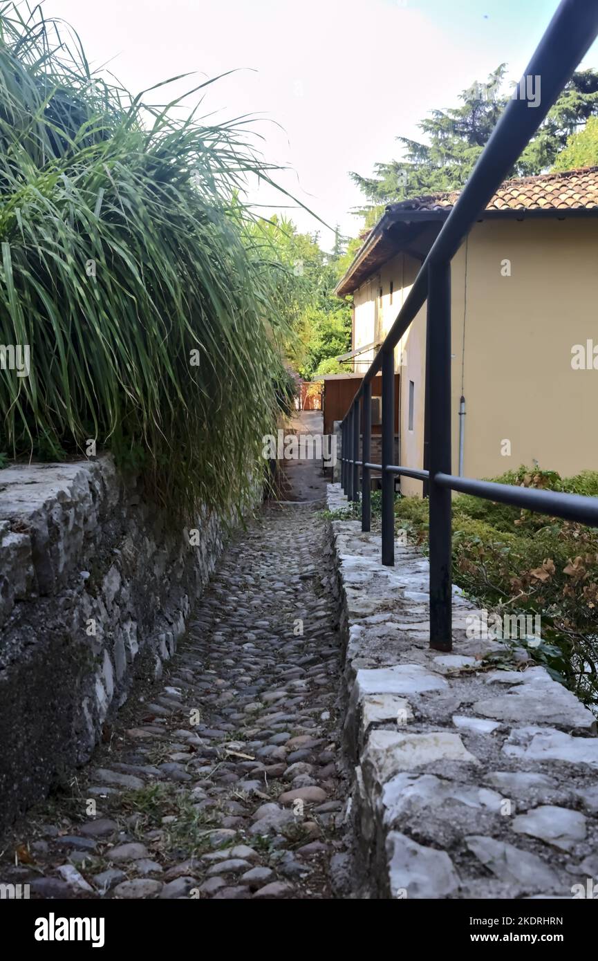 Narrow passageway behind a building in a park Stock Photo - Alamy