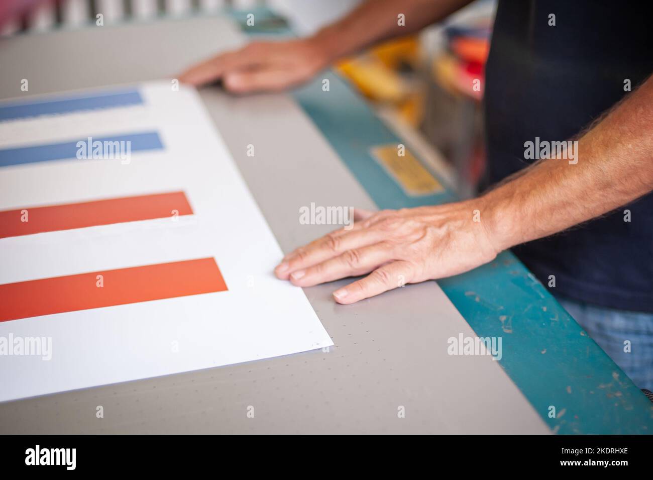 In the printing house, an experienced technician works on a screen ...