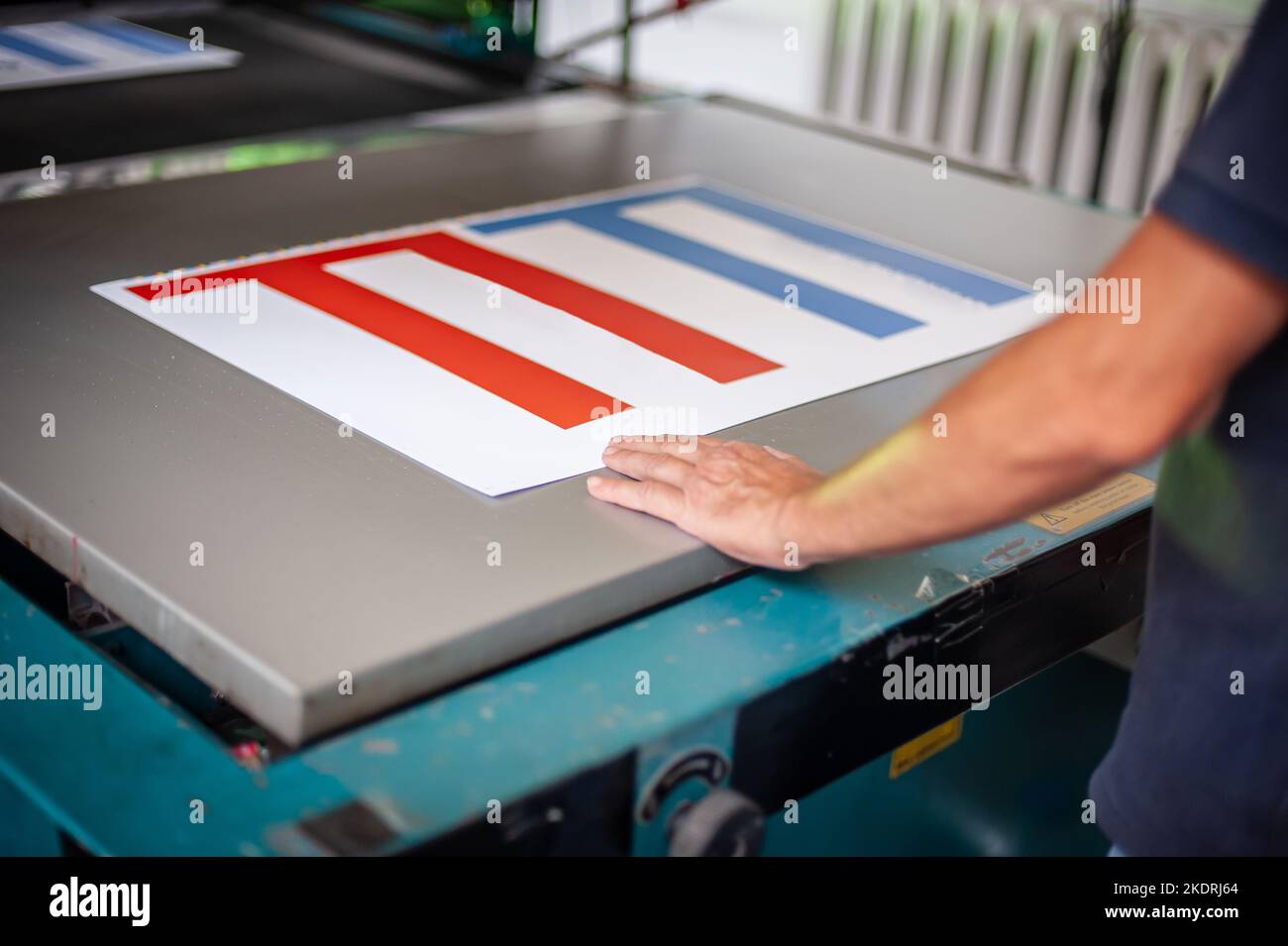 In the printing house, an experienced technician works on a screen ...