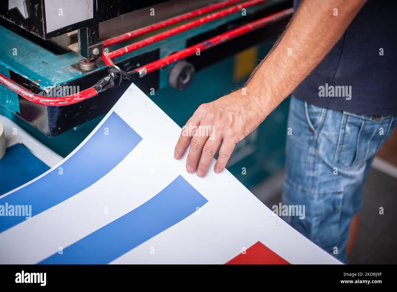 In the printing house, an experienced technician works on a screen ...