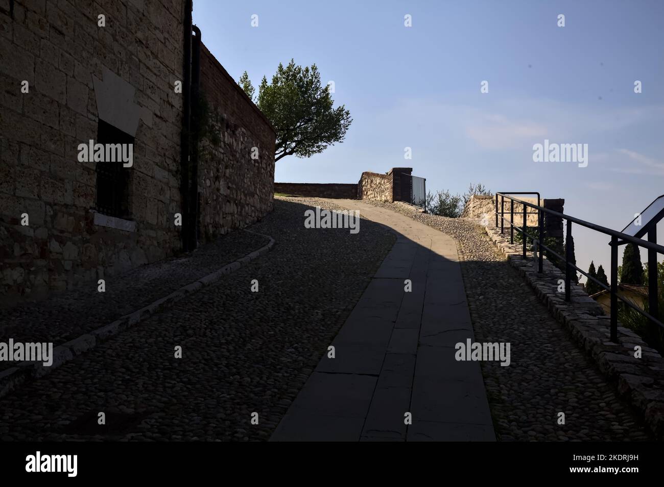 Uphill paved path of a castle with the sky as background Stock Photo ...