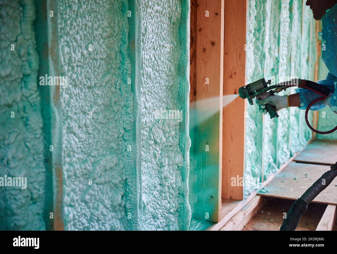 Builder insulating wooden frame house. Close up view of man worker ...