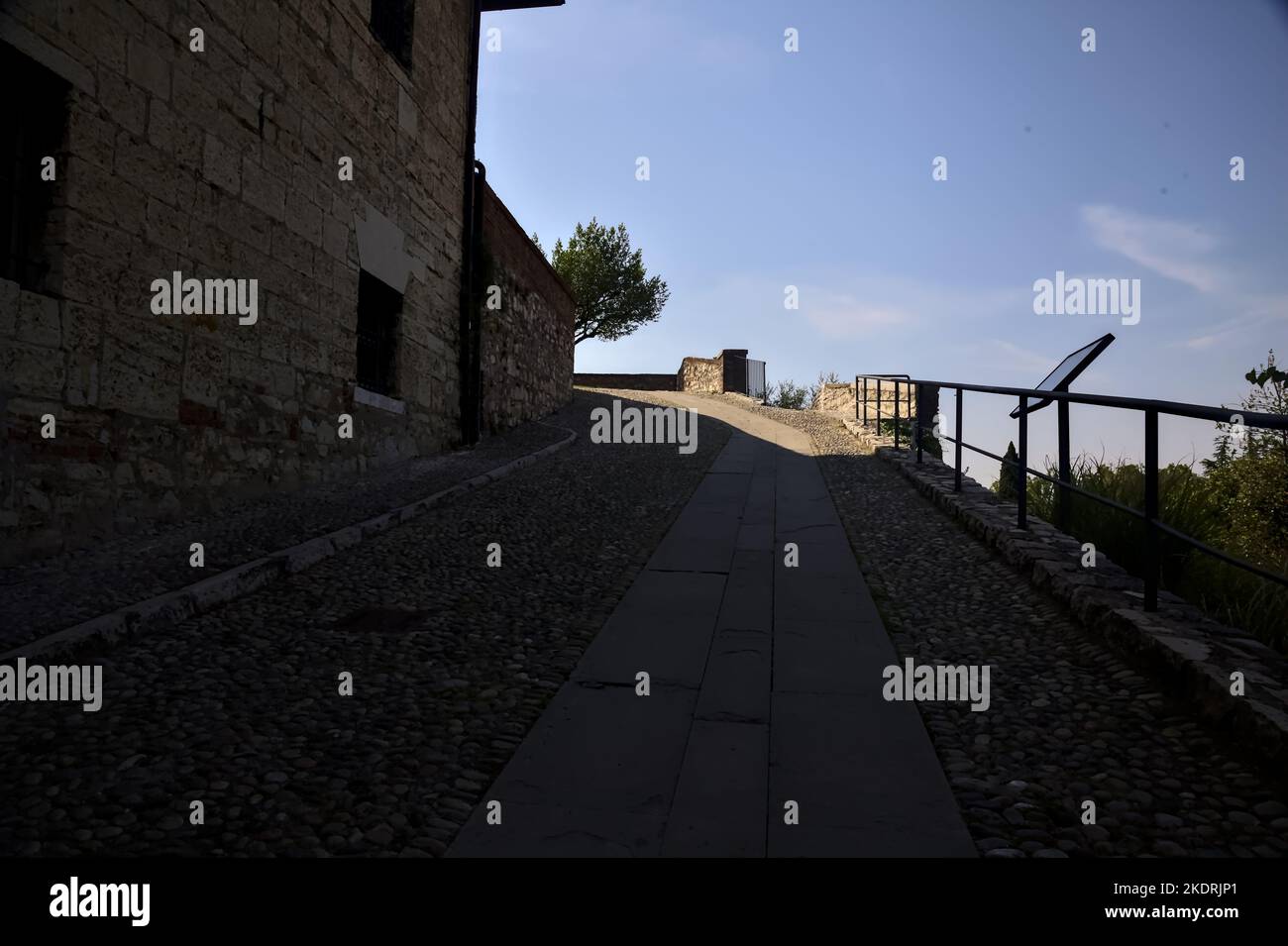 Uphill paved path of a castle with the sky as background Stock Photo ...