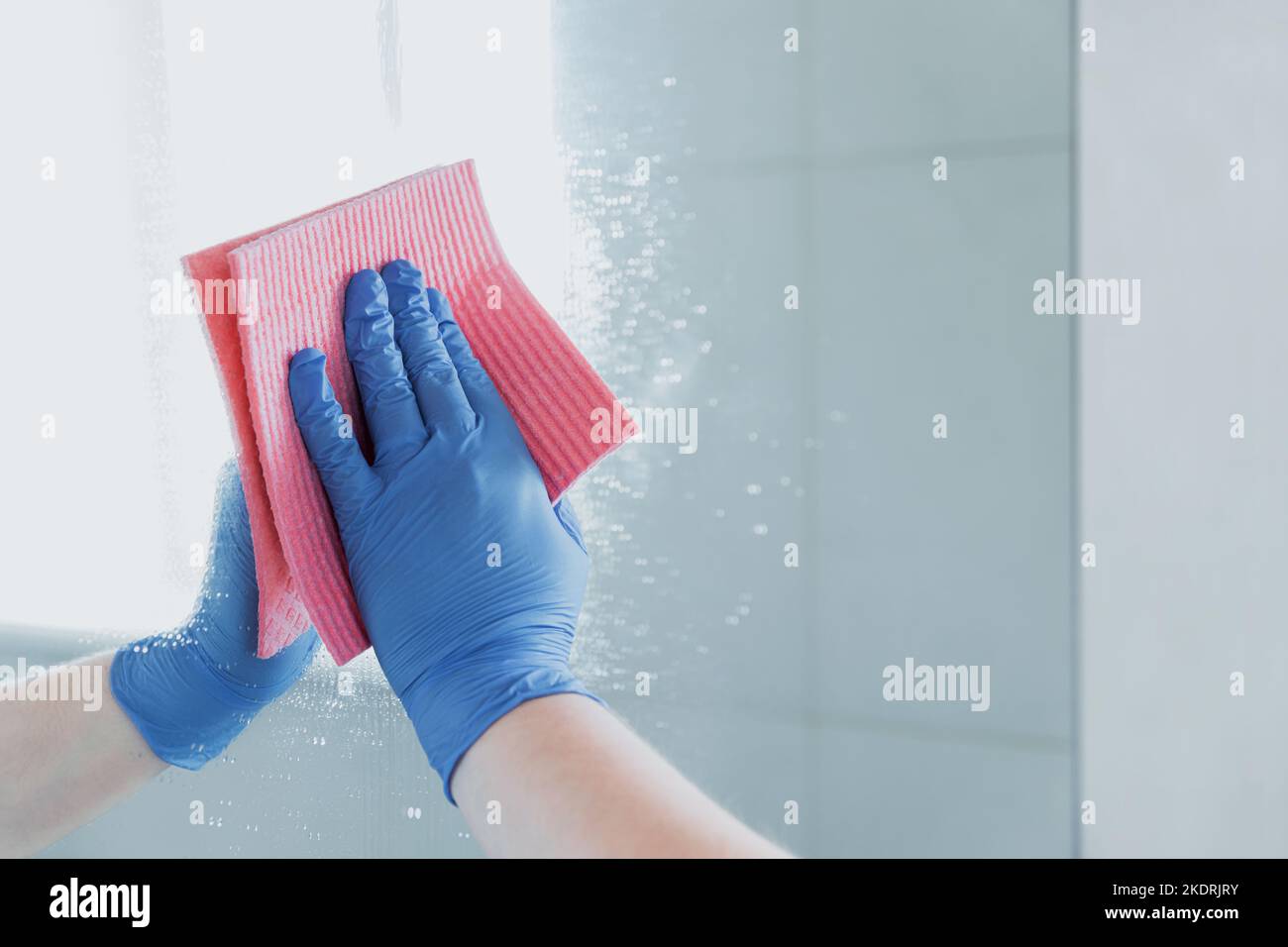 Cropped view of housekeeper woman hand in blue rubber glove polishing ...