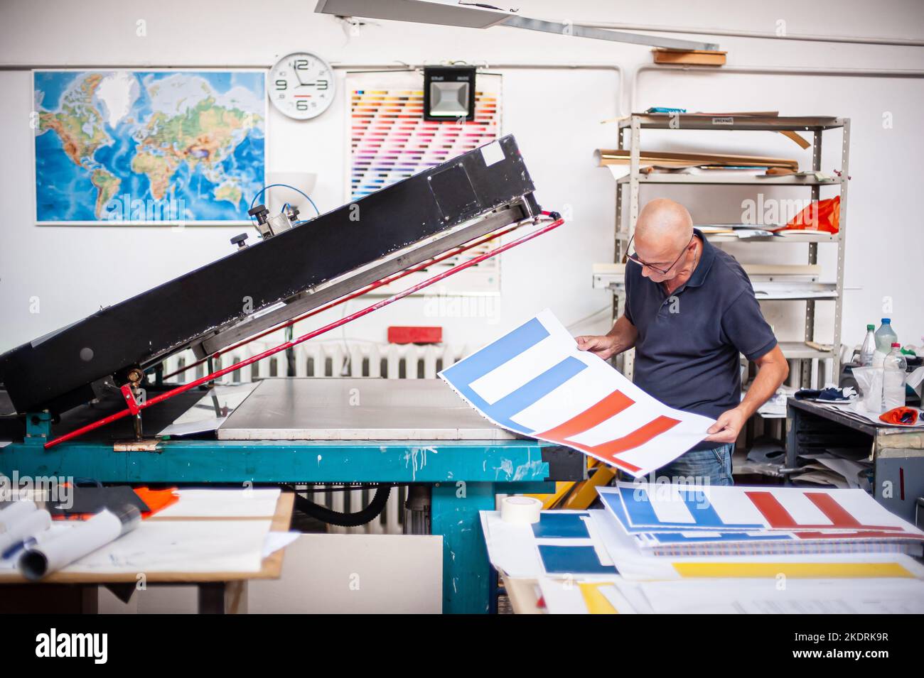 In the printing house, an experienced technician works on a screen ...