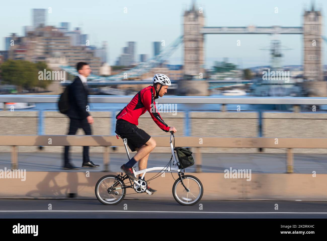 A male commuter riding a Brompton folding bicycle across London Bridge ...