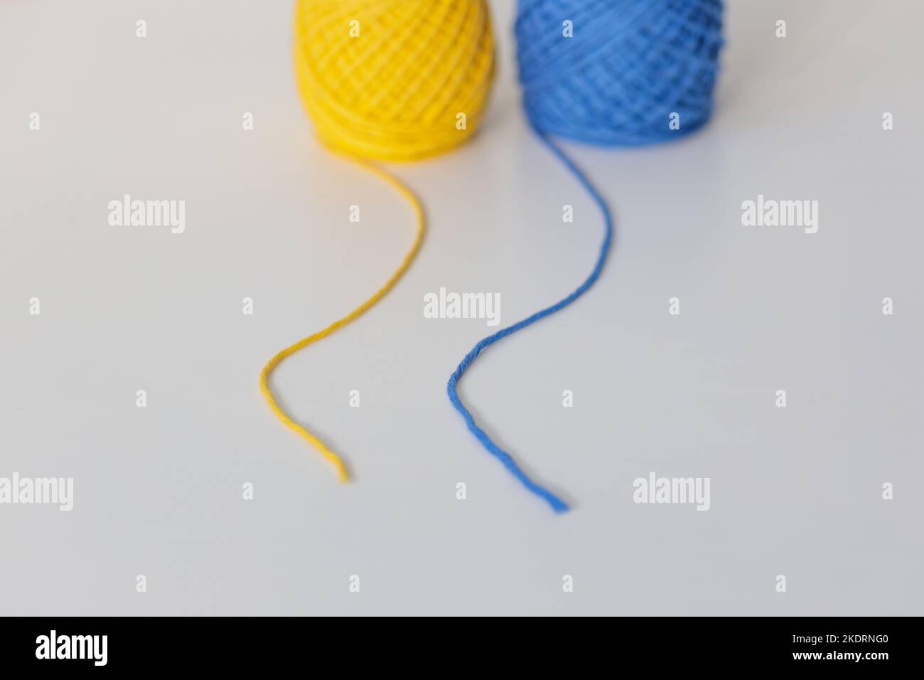 Yellow and blue threads on a gray background Stock Photo - Alamy