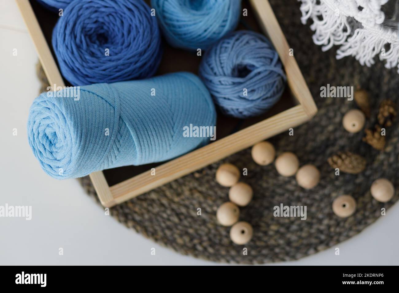 Composition of blue balls of thread in a wooden box, wooden necklace ...