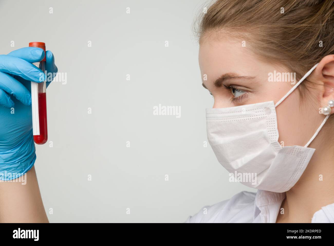 young woman with medical face mask and medical gloves is handling a ...