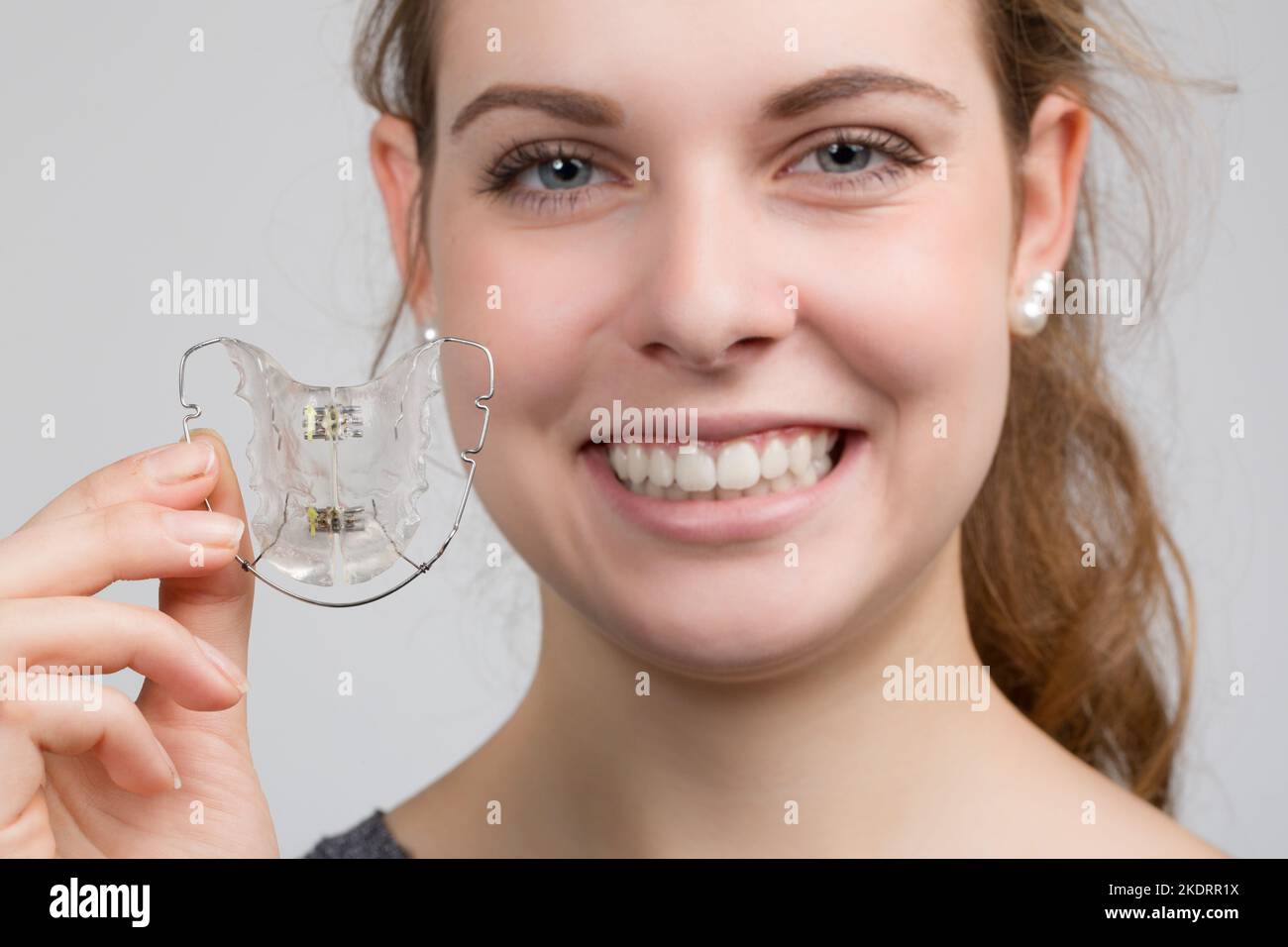 young girl is smiling and shows her removable dental brace Stock Photo ...