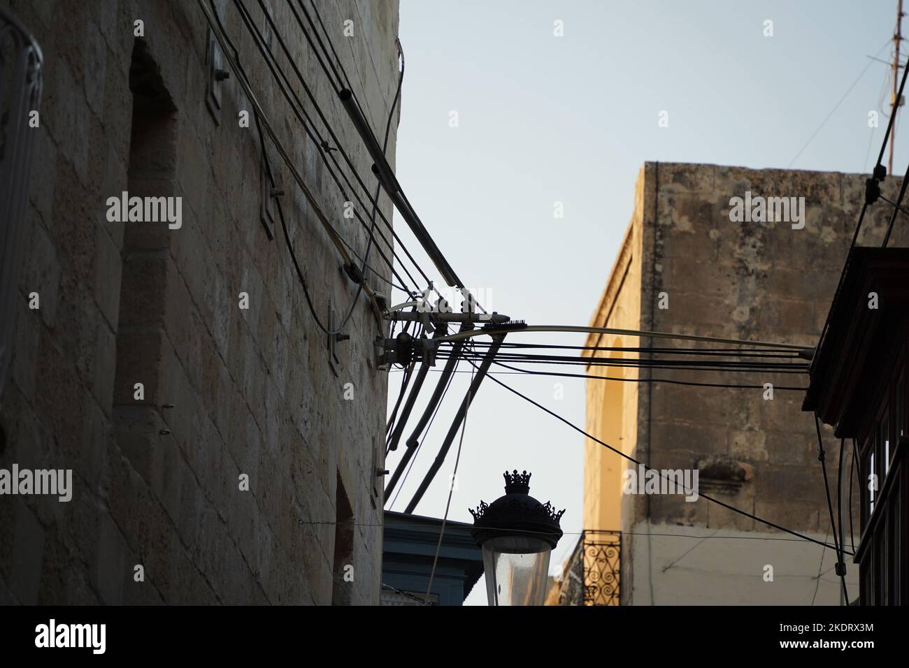 Malta electric wires hanging on building detail Stock Photo - Alamy