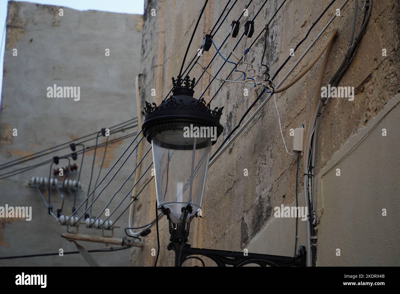 Malta electric wires hanging on building detail Stock Photo - Alamy
