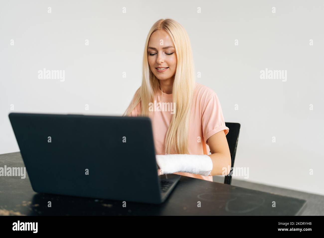 Studio portrait of cheerful business woman with broken arm wrapped in ...