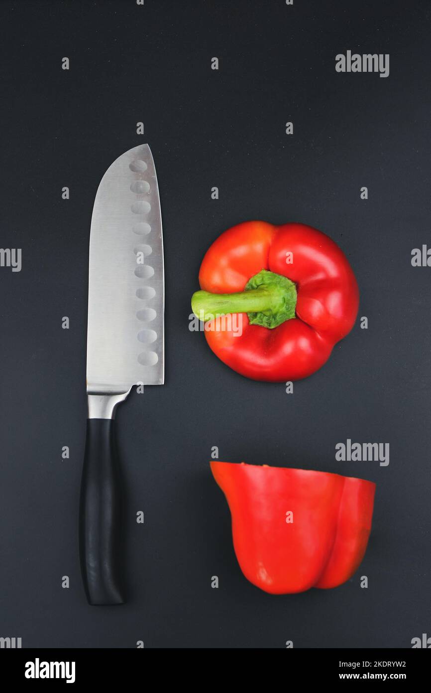 A tomato cut into two halves with a sharp knife. A Sharp knife and a ...