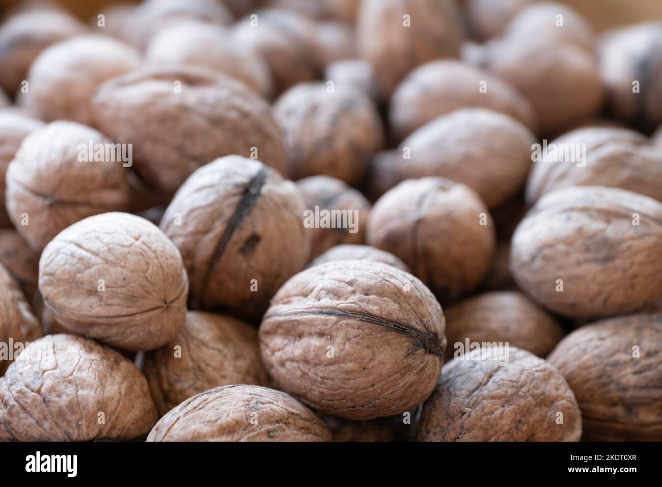 Walnut background. Group of walnuts, narrow depth of field. Focus on ...