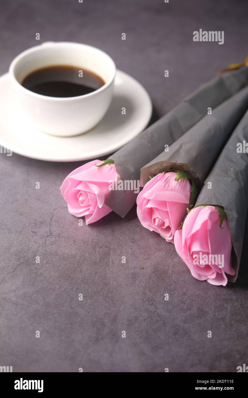 flat composition coffee, tulip flower and eyeglass on black background ...