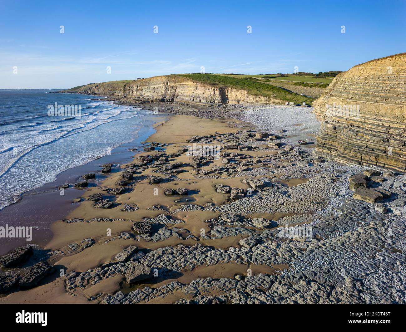 Aerial view of large limestone cliffs and a sandy beach next to the ...