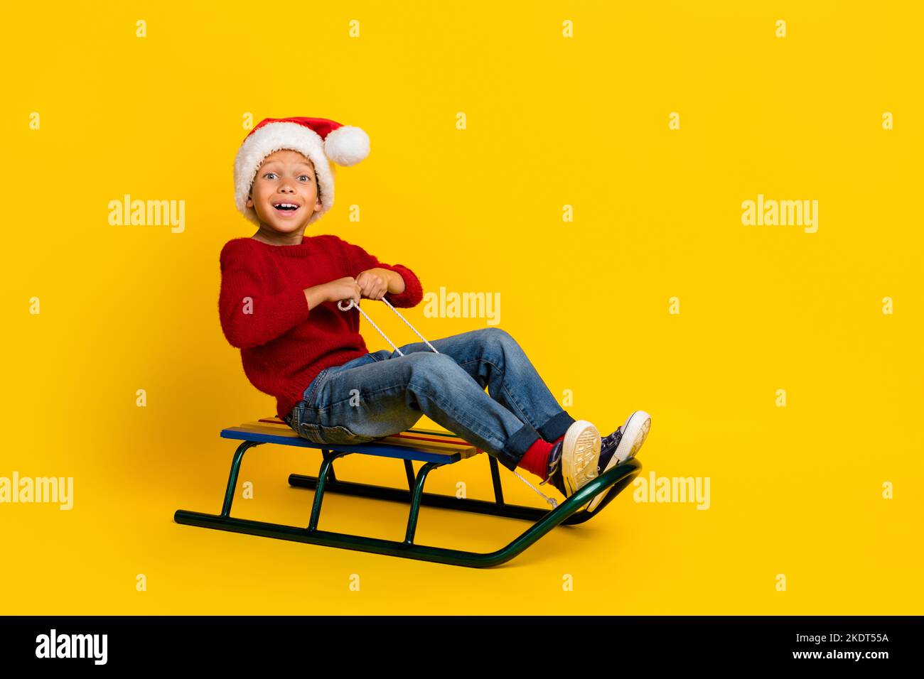 Full length photo of cute little boy excited riding fast speed sledge ...