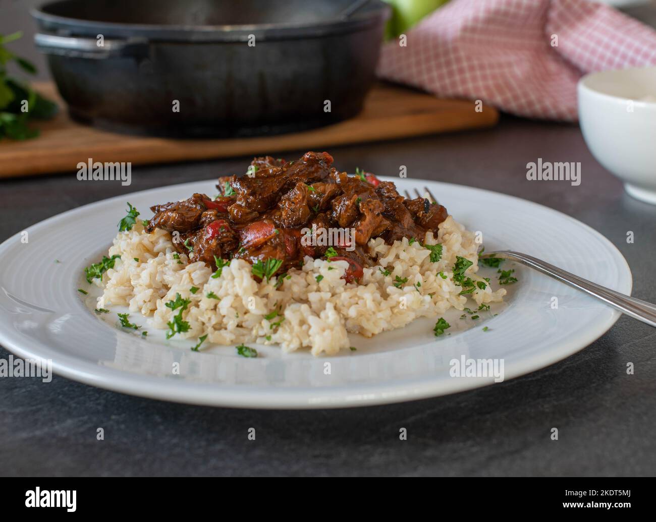 Beef stew with brown rice on a plate Stock Photo - Alamy