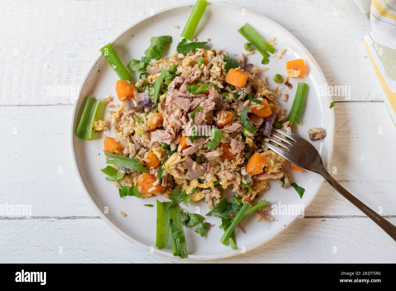 Fried rice with vegetables and tuna on a white plate. Cooked with brown ...