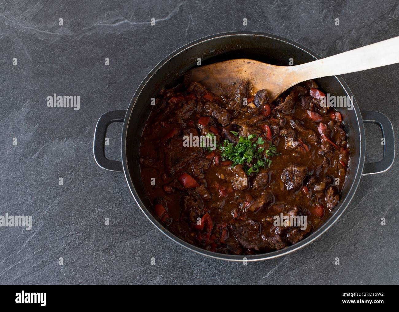 Pot with fresh cooked spicy beef stew isolated on dark background from ...