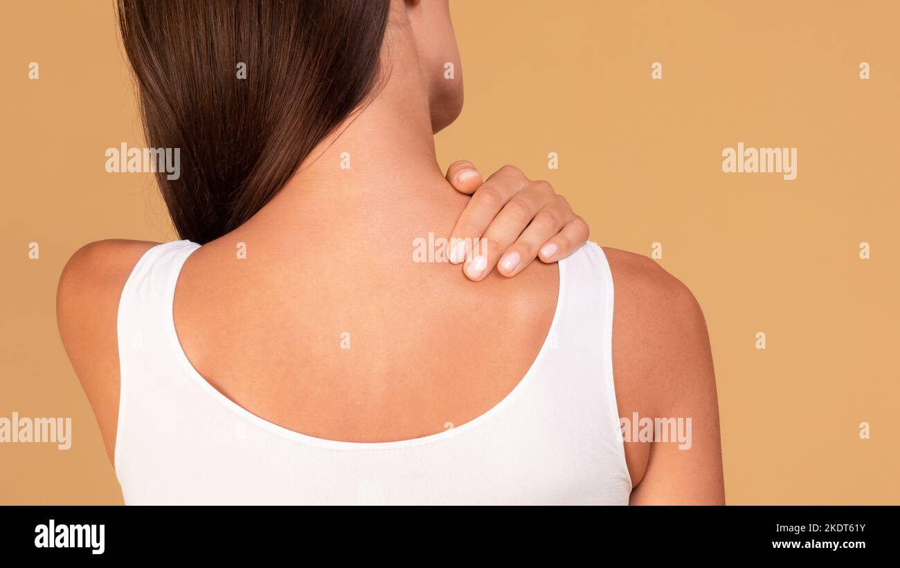 Young caucasian woman suffering from acute pain in her shoulder ...
