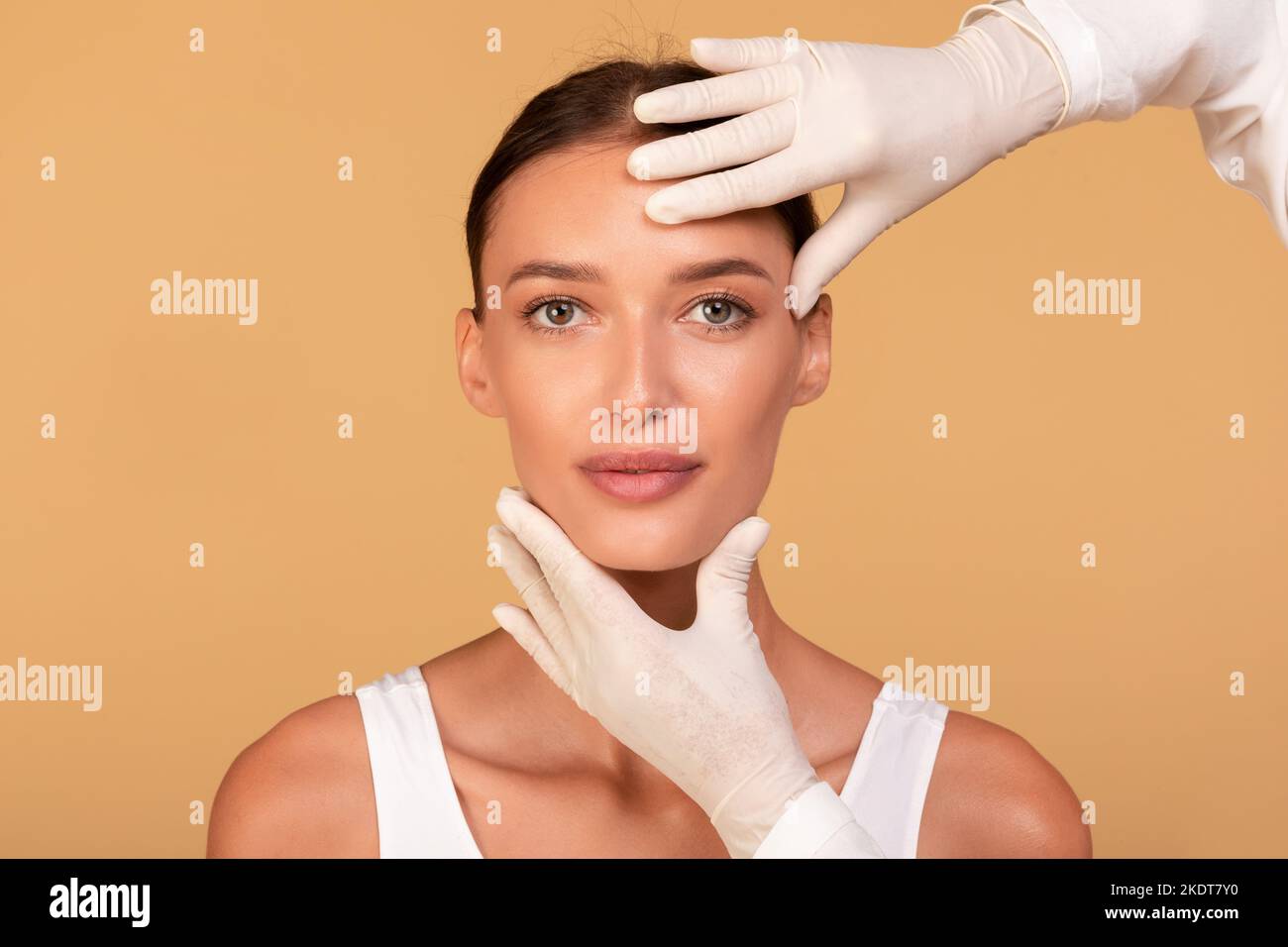 Cosmetic surgery concept. Doctor examining young caucasian woman's face ...