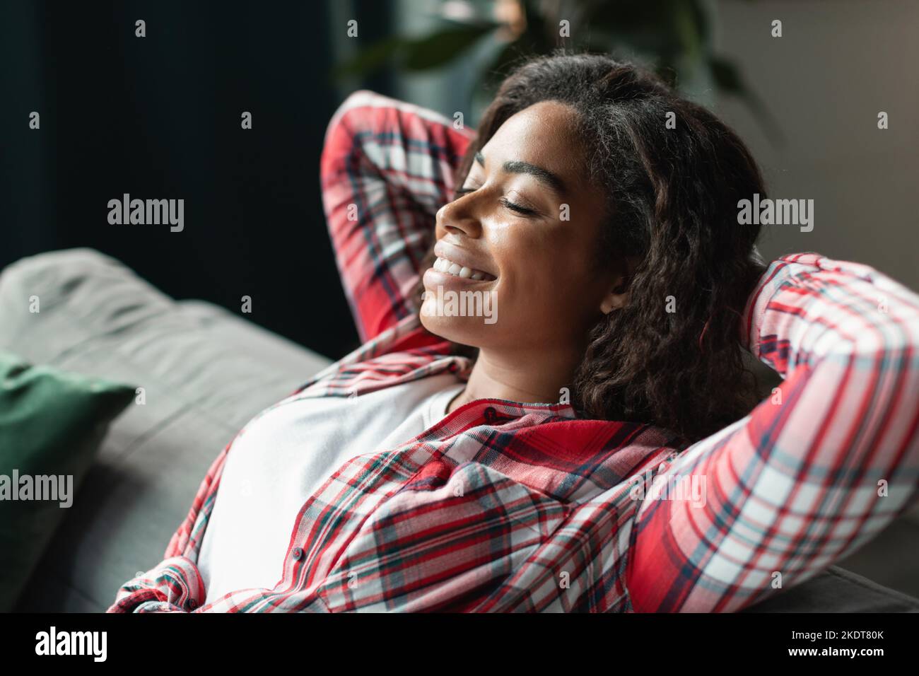 Glad happy pretty black young female with closed eyes resting alone on ...