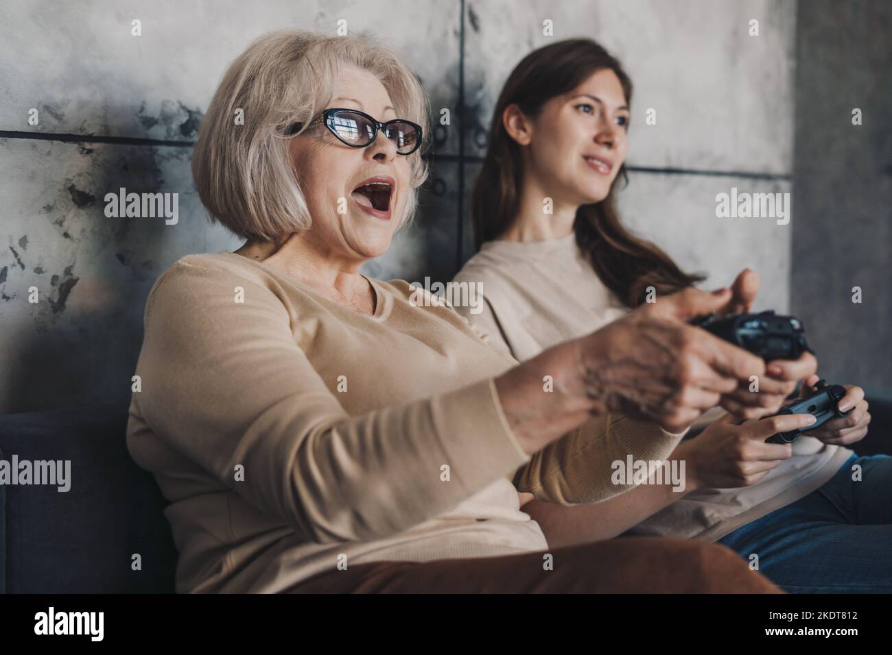 Two age generations women family, having fun enjoying play video game ...
