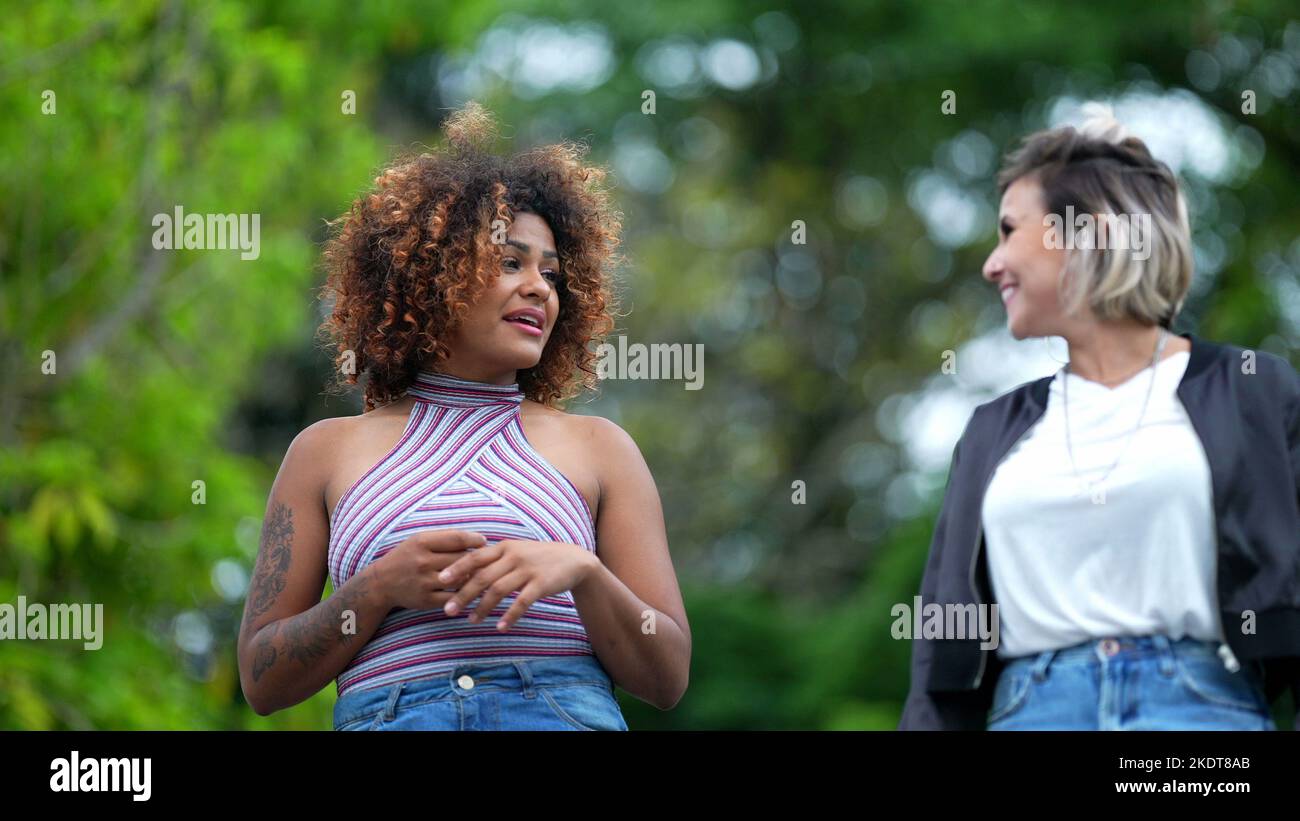 Two Brazilian friends hanging together outside in street. diverse ...