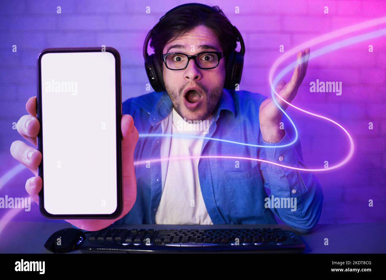 Shocked guy gamer showing smartphone with blank screen Stock Photo - Alamy