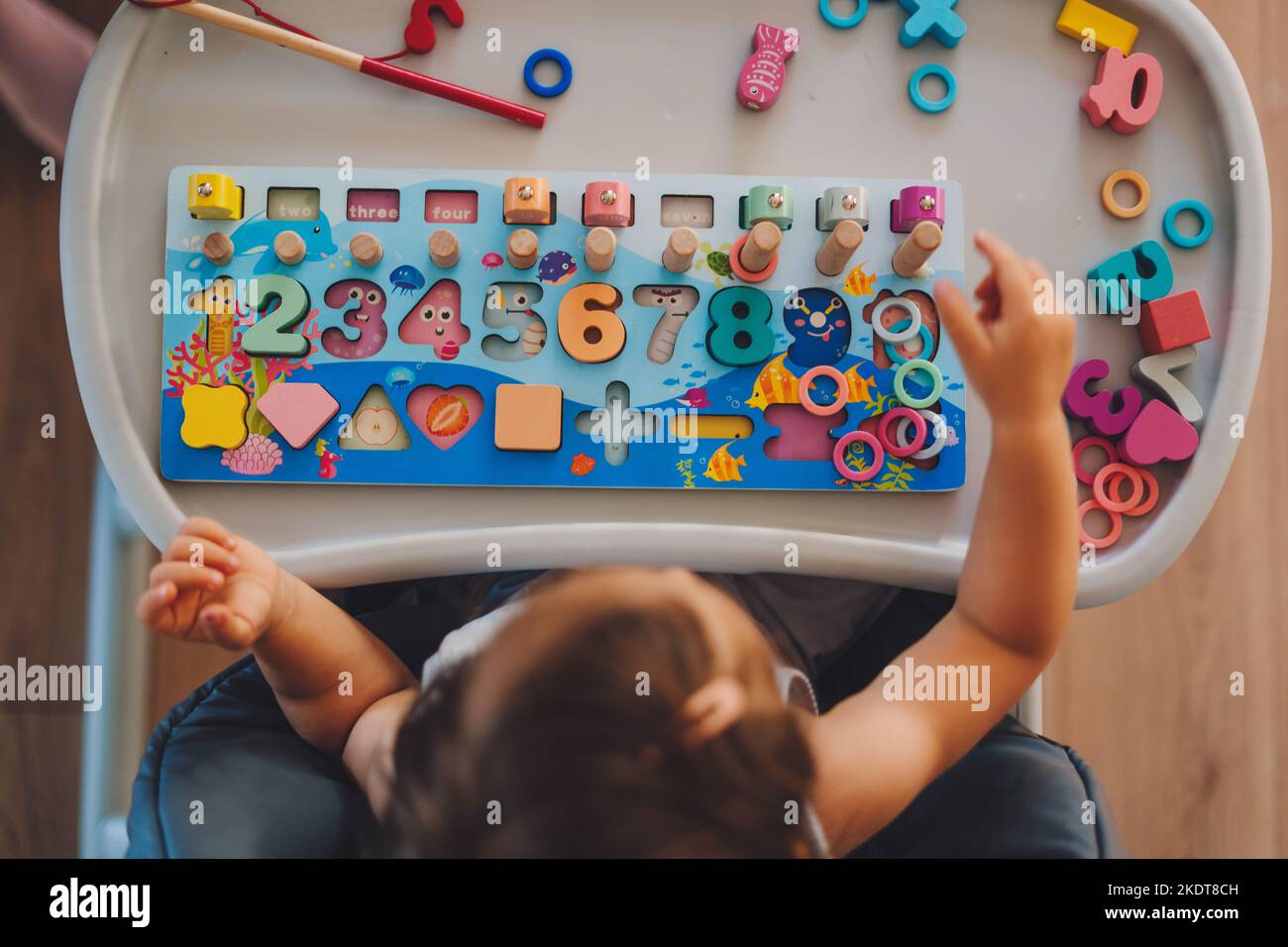 Baby girl playing, learning numbers, counting with help of a wooden ...