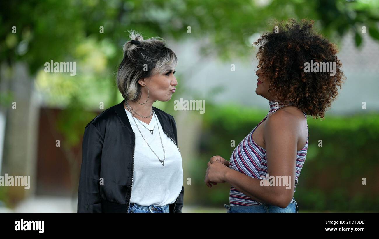 Two diverse friends talking outside at park. people conversation Stock ...