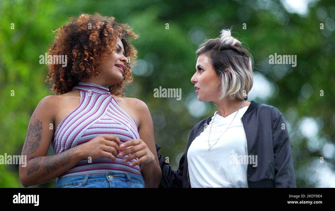 Two Brazilian friends hanging together outside in street. diverse ...