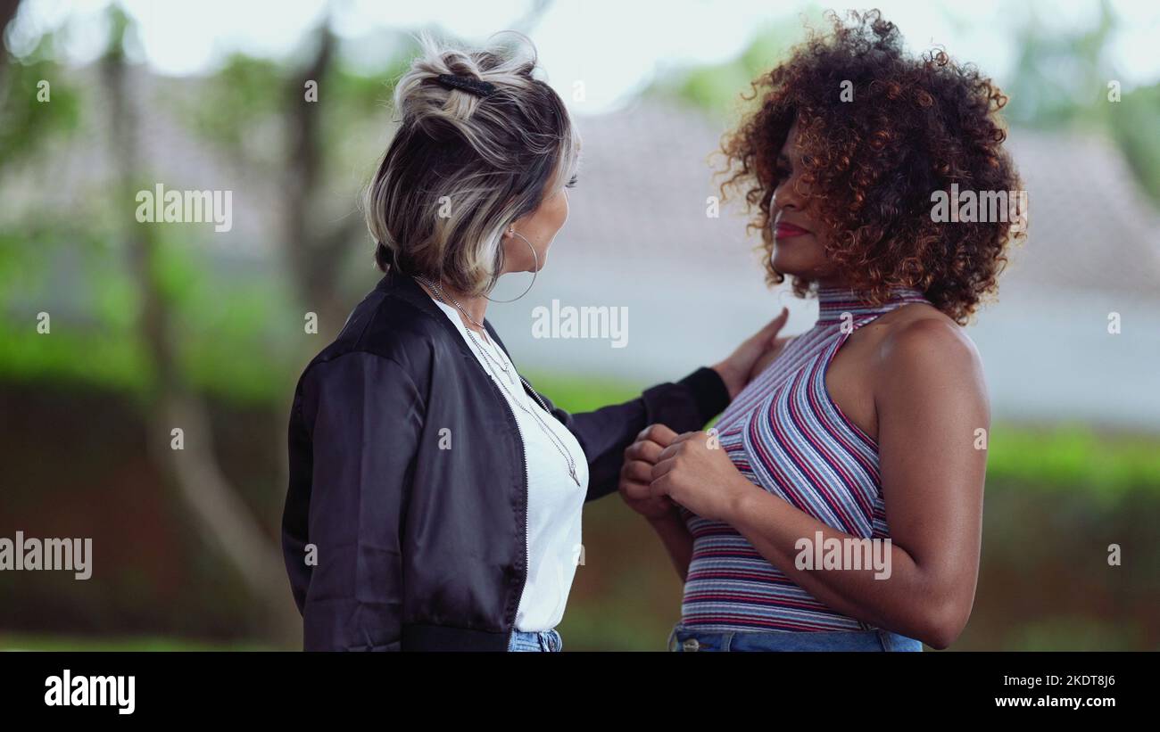Two diverse friends talking outside at park. people conversation Stock ...