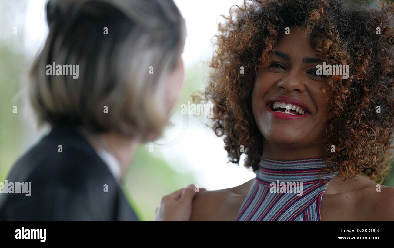 Two diverse friends talking outside at park. people conversation Stock ...