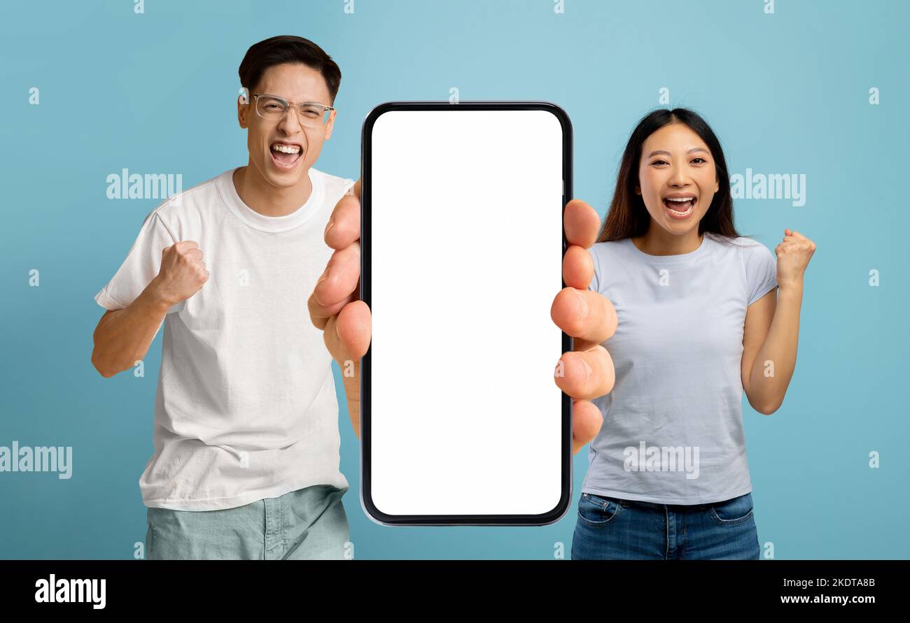 Emotional Asian Couple Holding Big Smartphone With White Screen And ...