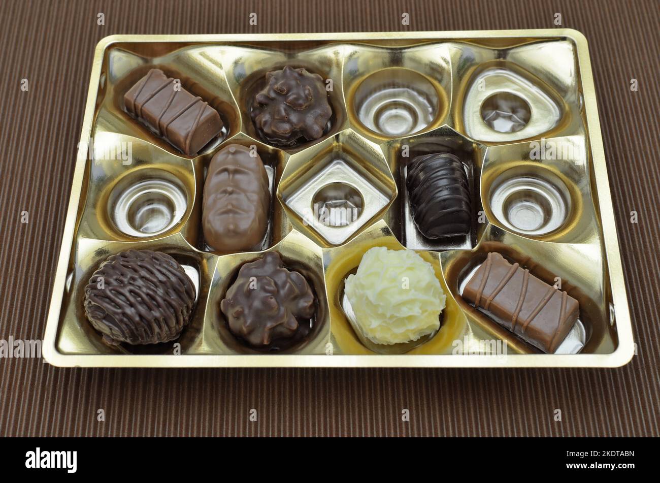 chocolates in a box, close up, isolated on brown background, top view ...