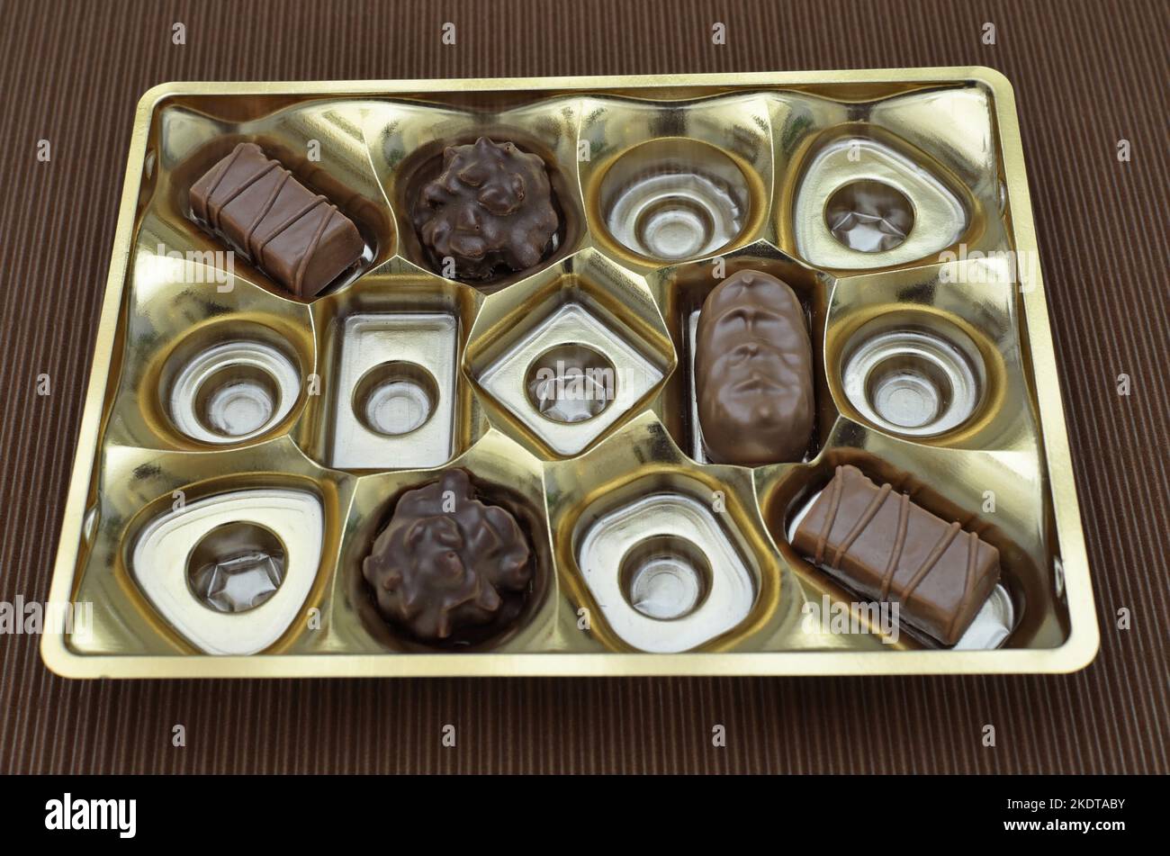 chocolates in a box, close up, isolated on brown background, top view ...