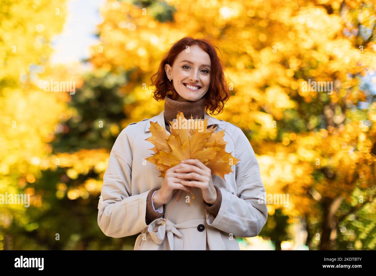 Cheerful Caucasian Millennial Woman With Red Hair In Raincoat With